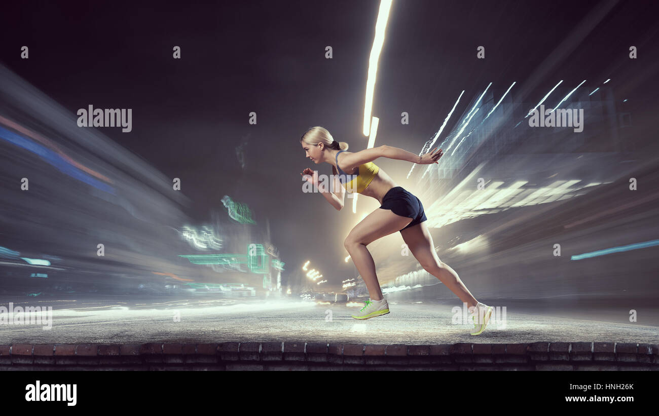 Young woman athlete running fast on dark background Stock Photo - Alamy