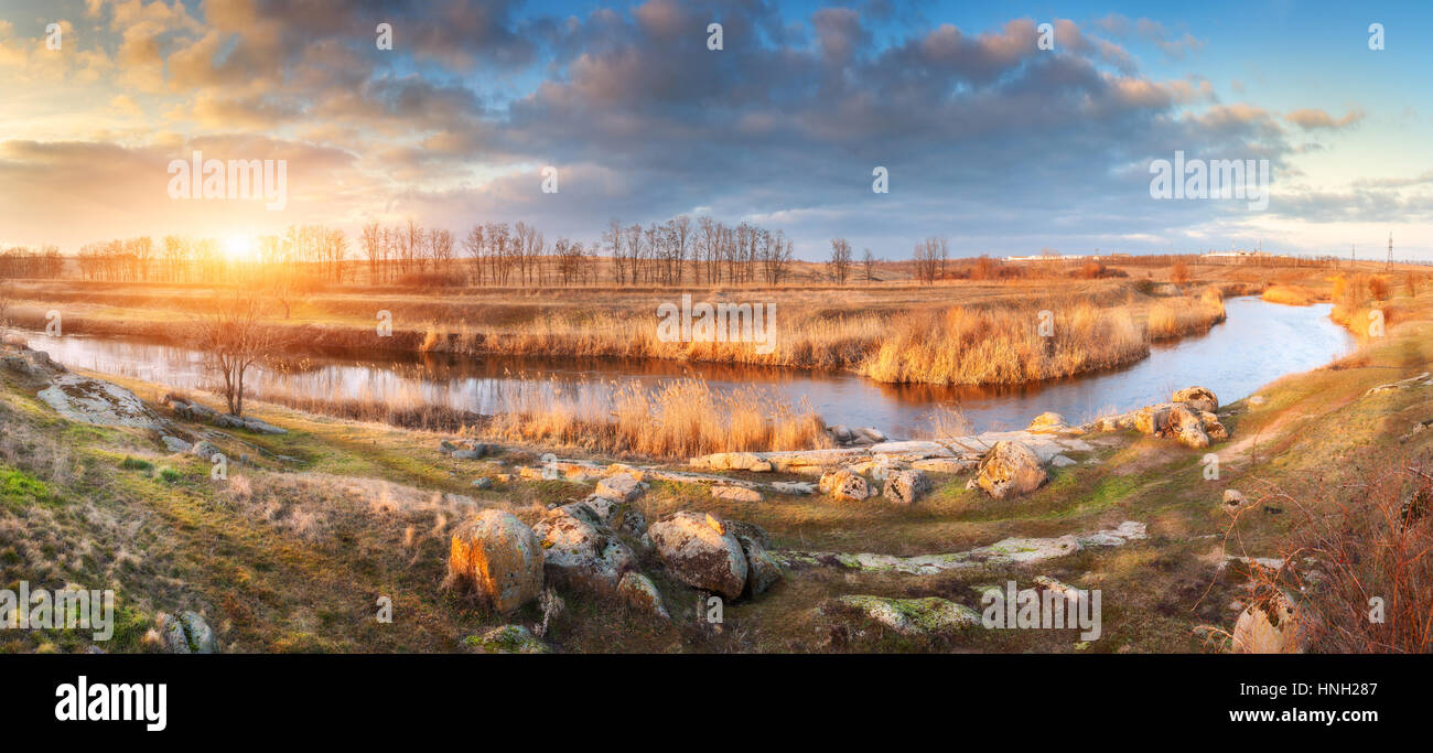 Summer landscape at sunset. Big stones at the river against blue sky ...