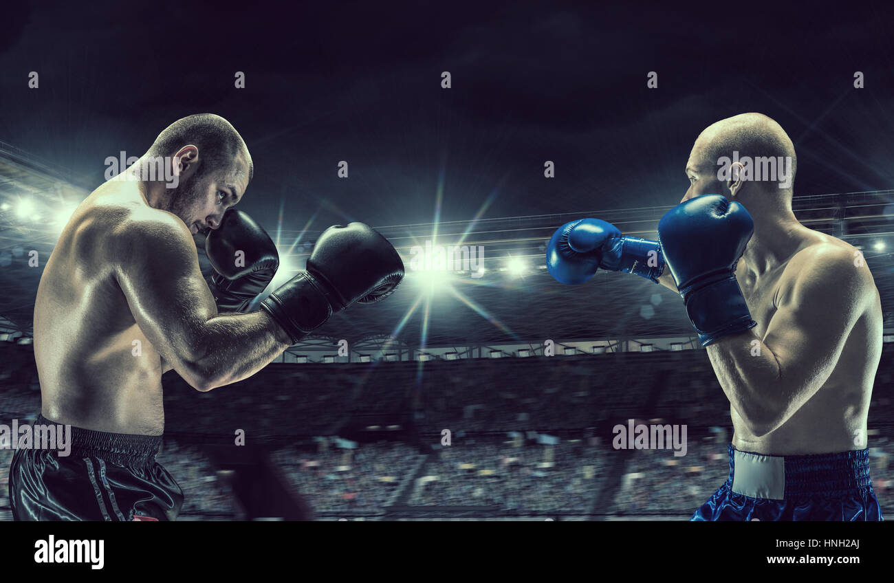 Two professional boxers fighting at sport arena. Mixed media Stock ...