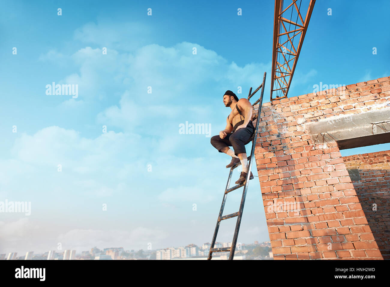 Builder with bare torso sitting on ladder Stock Photo - Alamy