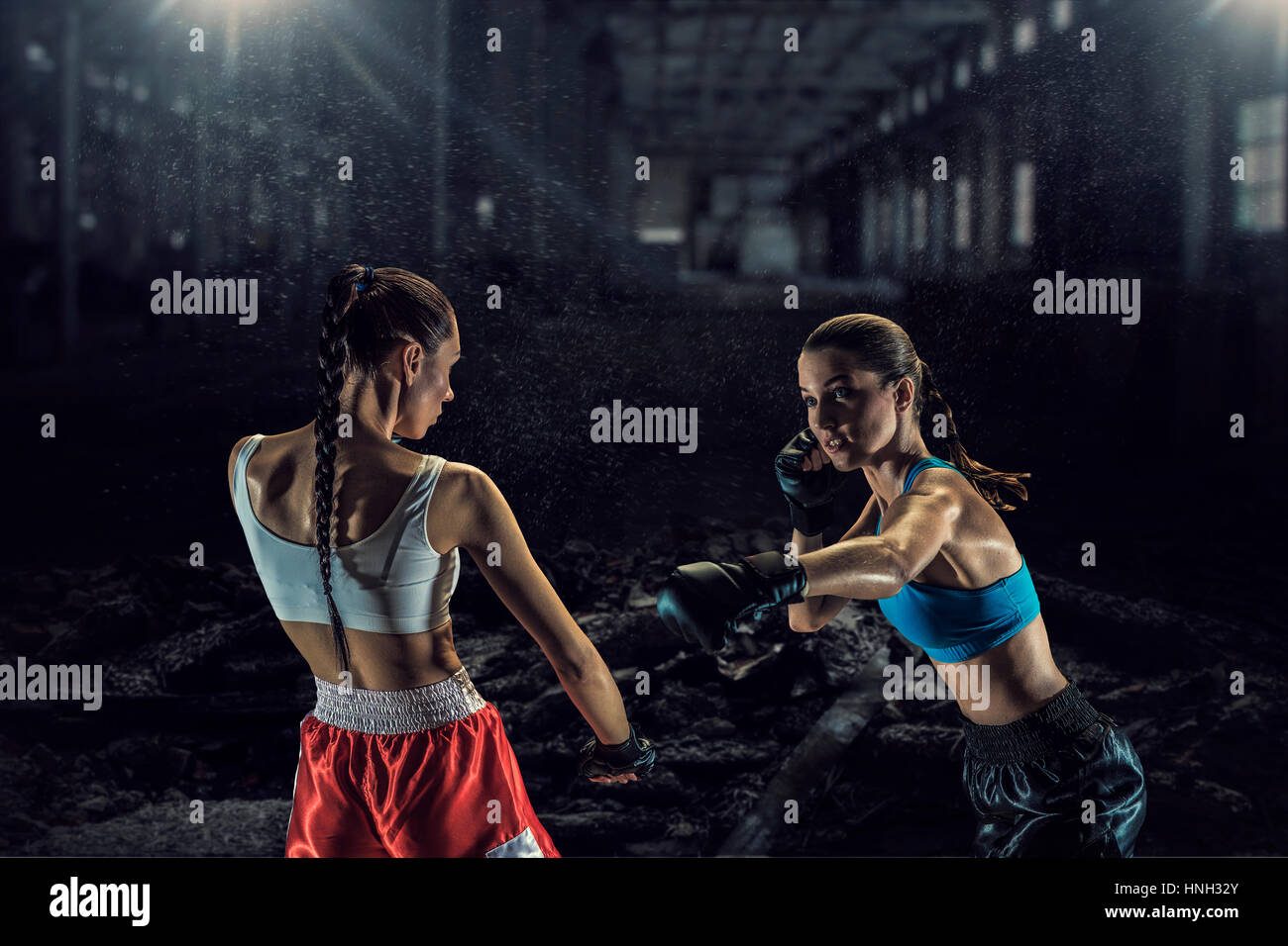 Two young pretty women boxing in dark old building. Mixed media Stock ...