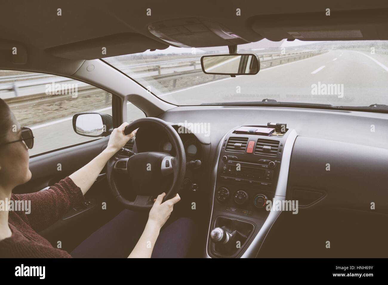 Young woman driving a car on highway Stock Photo - Alamy