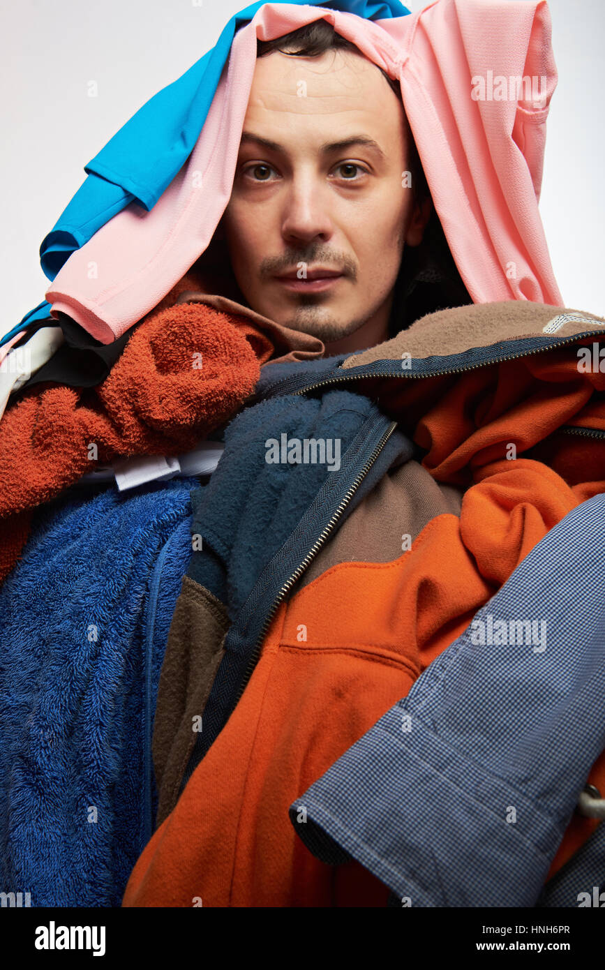 Man under messy clothes. Men face throw clothes isolated on white ...
