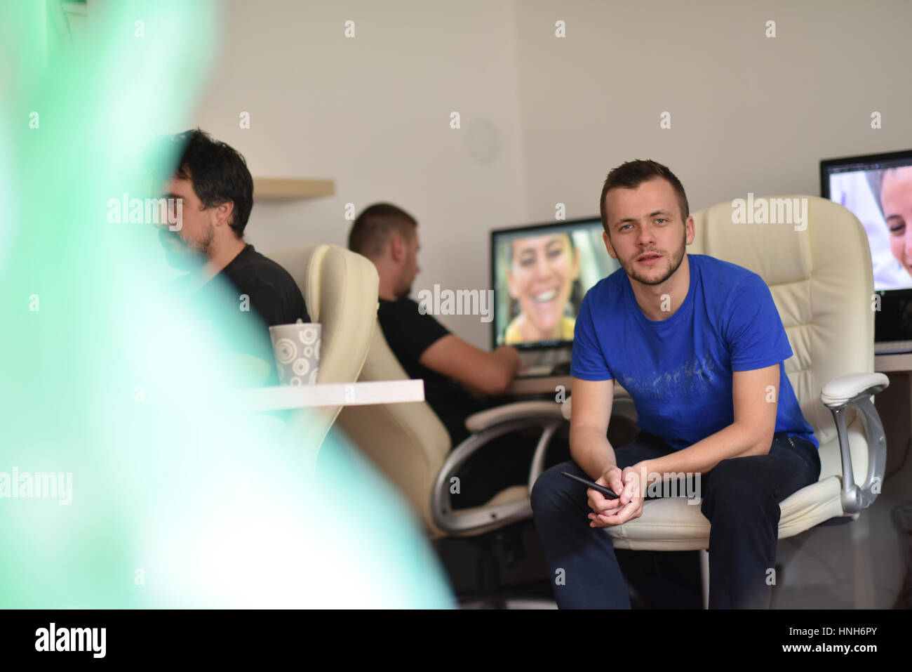 a group of young graphic designers working on a digital tablet and a ...