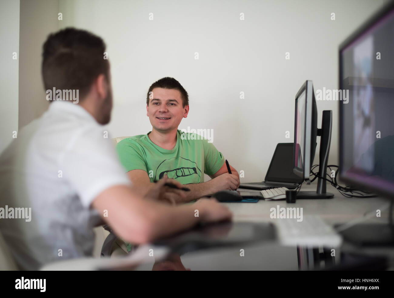 a group of young graphic designers working on a digital tablet and a ...