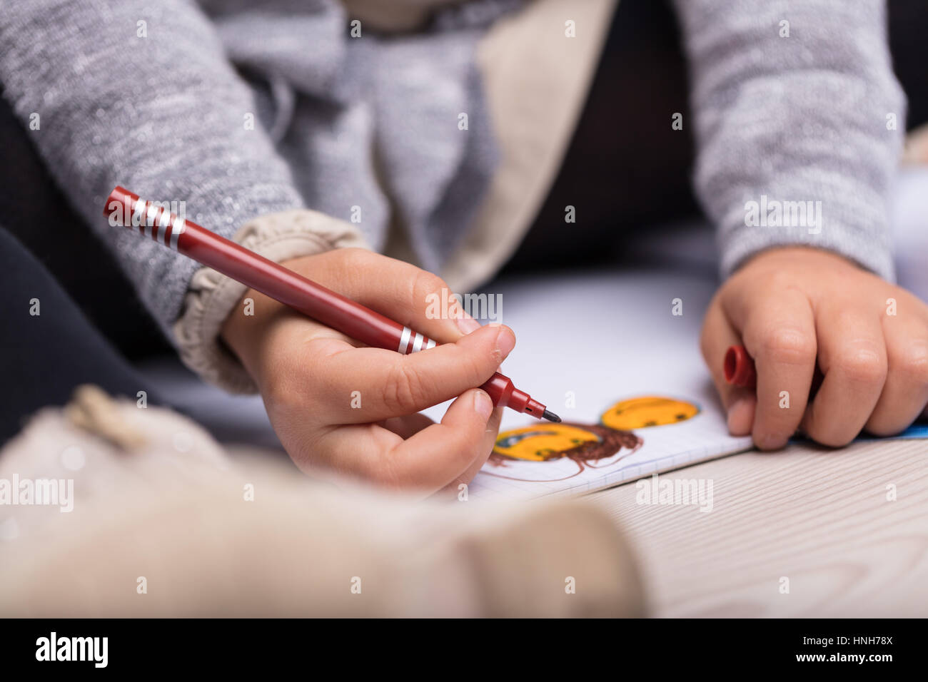 Artistic little girl making a colorful drawing on a sheet of paper with ...