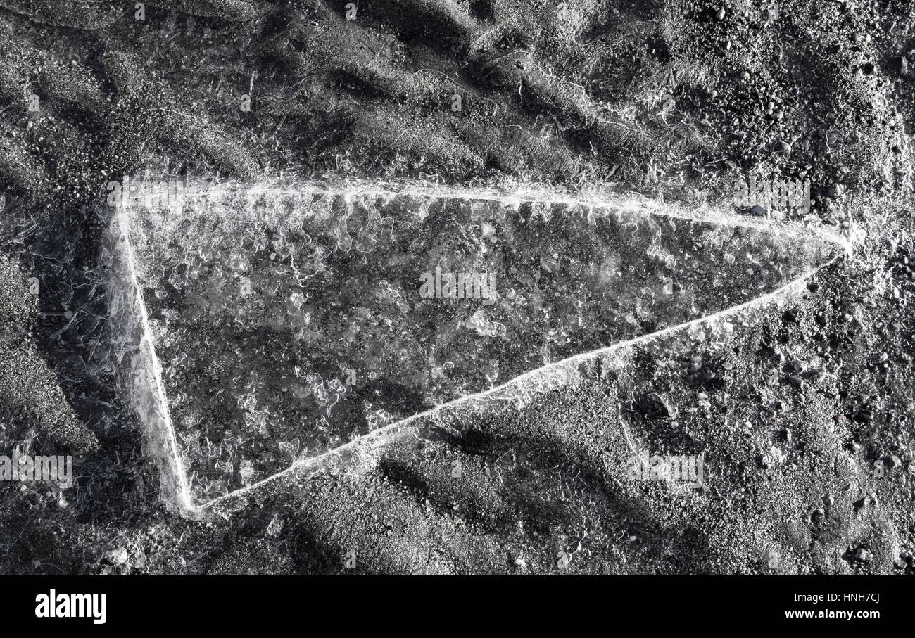 Glowing triangle of sea ice on a beach in Southeast Alaska in winter in ...