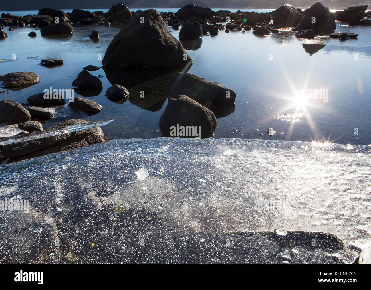 Ice chunk on Alaskan beach with reflected sunburst Stock Photo - Alamy