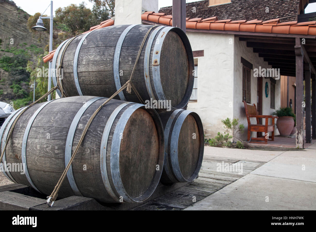 Vintage wooden alcohol barrels stacked three together on the deck of a ...