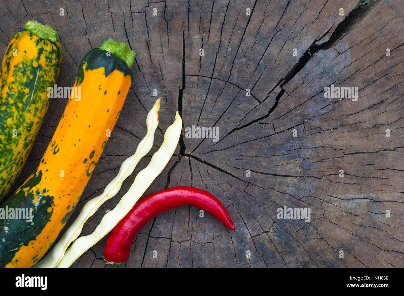 unusual green-orange zucchini, pods of white beans and red chilly on an ...