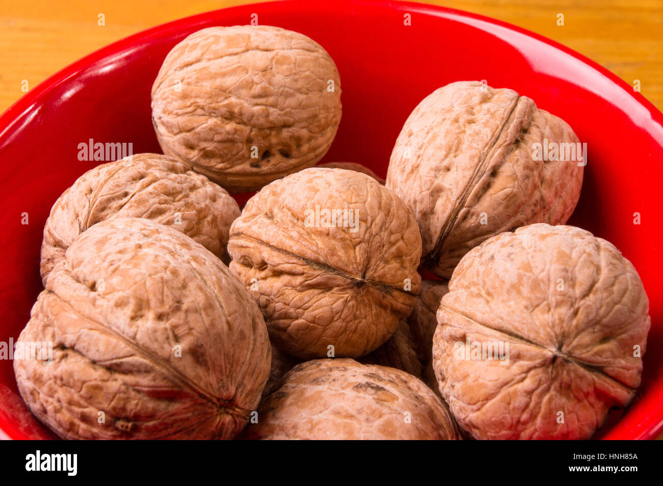 walnuts in red plate on wooden background Stock Photo - Alamy