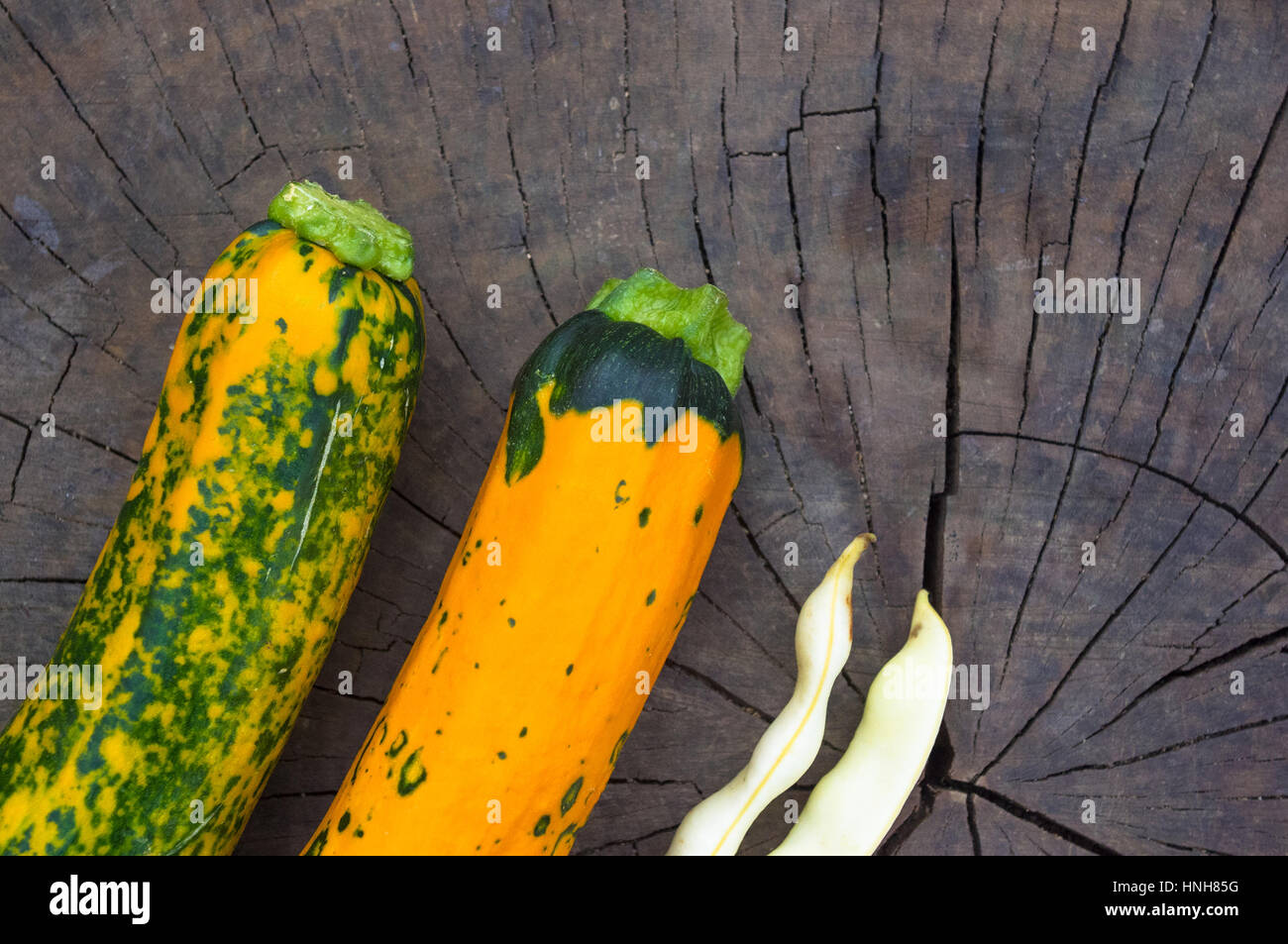 unusual green-orange zucchini, pods of white beans and red chilly on an ...