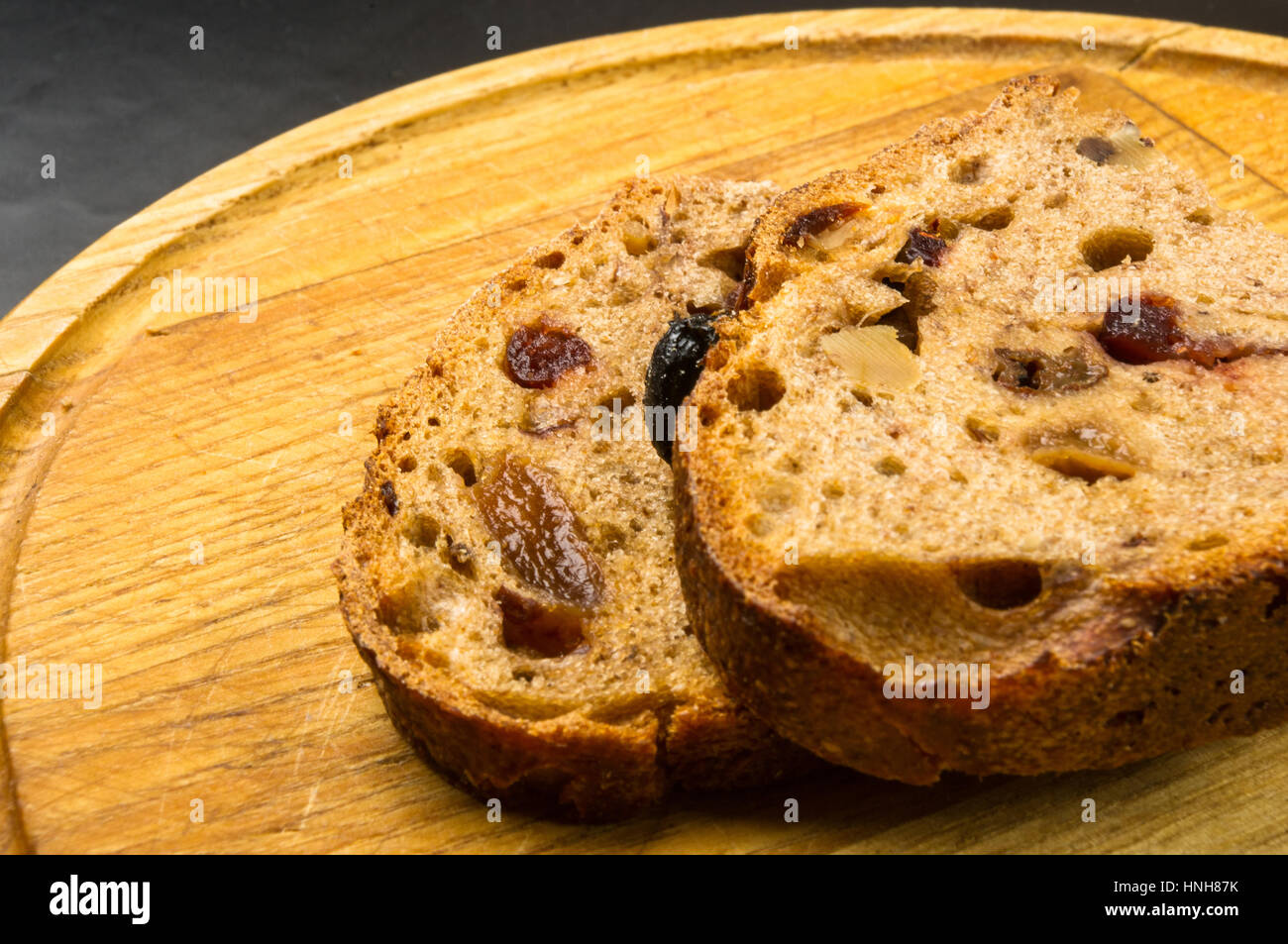 Slices of malt bread handmade with nuts, raisins and cranberries on ...