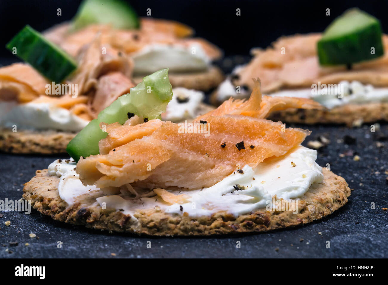 Salmon and cucumber canapes on oat cakes with black cracked pepper ...