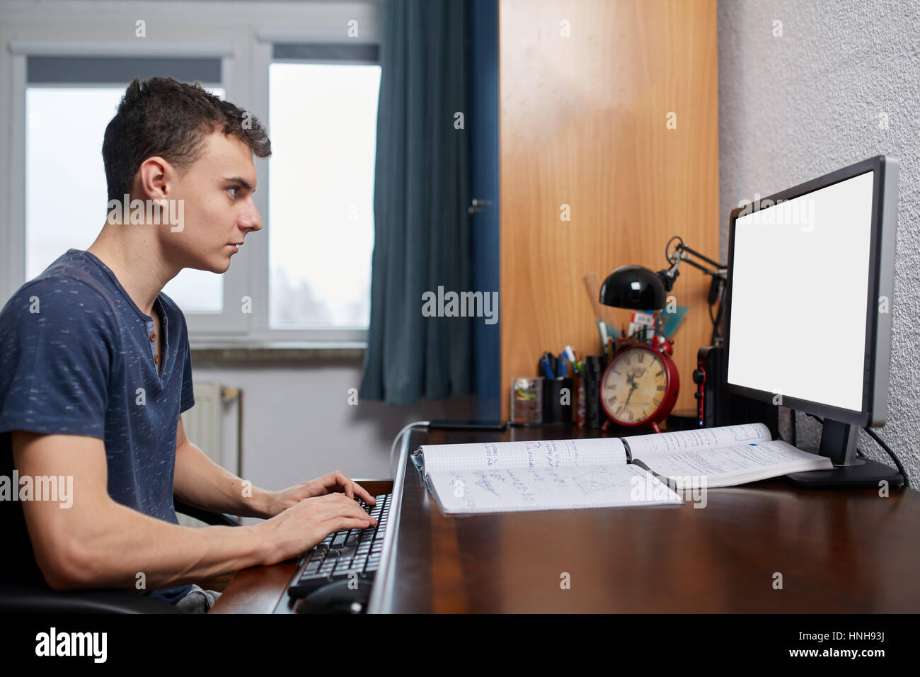 Teenage boy doing homework with the help of computer Stock Photo - Alamy