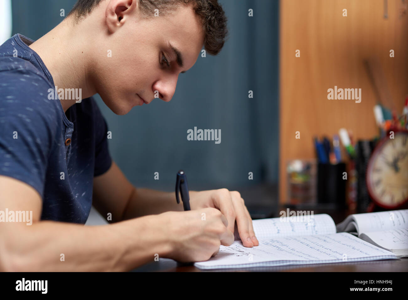 Teenage boy doing homework at his desk at home Stock Photo - Alamy