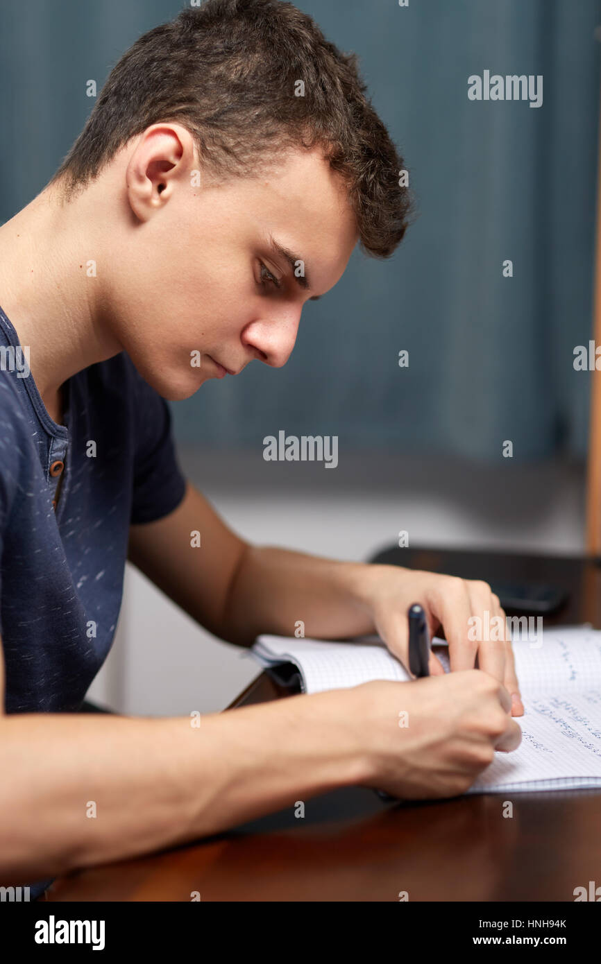 Teenage boy doing homework at his desk at home Stock Photo - Alamy
