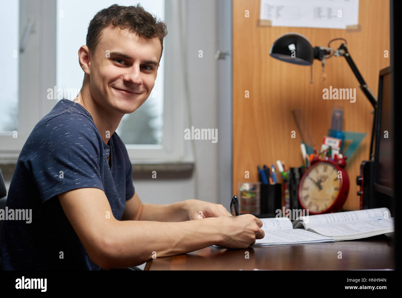 Teenage boy doing homework at his desk at home Stock Photo - Alamy
