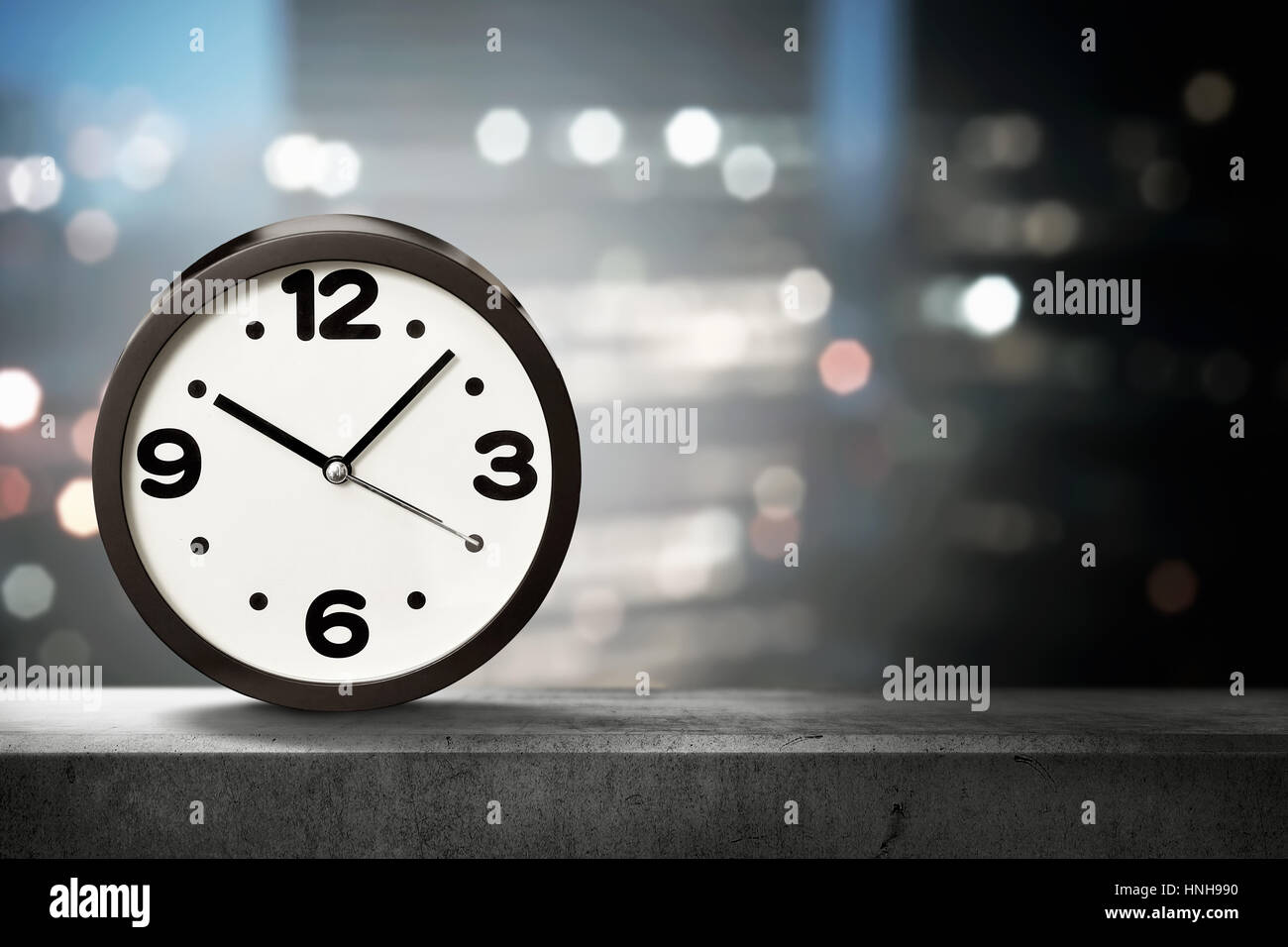 One black clock on the low wall with blurred city lights. Earth Hour ...