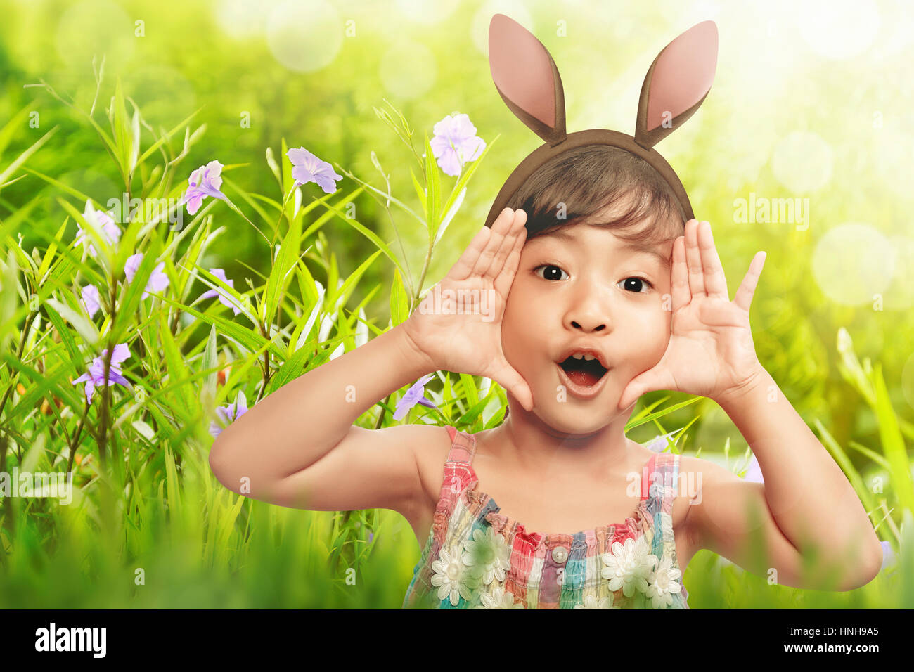 Happy girl expression with bunny ears in the garden Stock Photo - Alamy