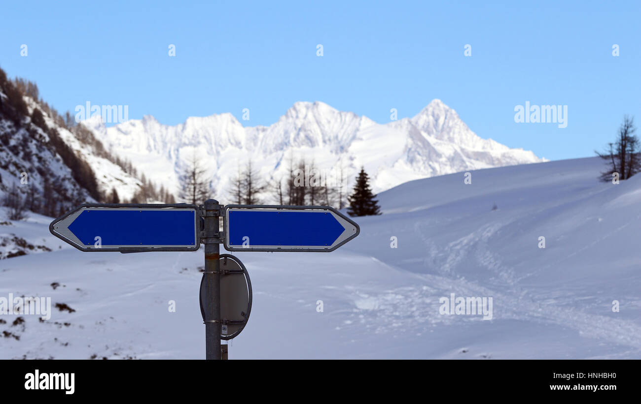Blank road direction signs in front of a winter mountain landscape ...