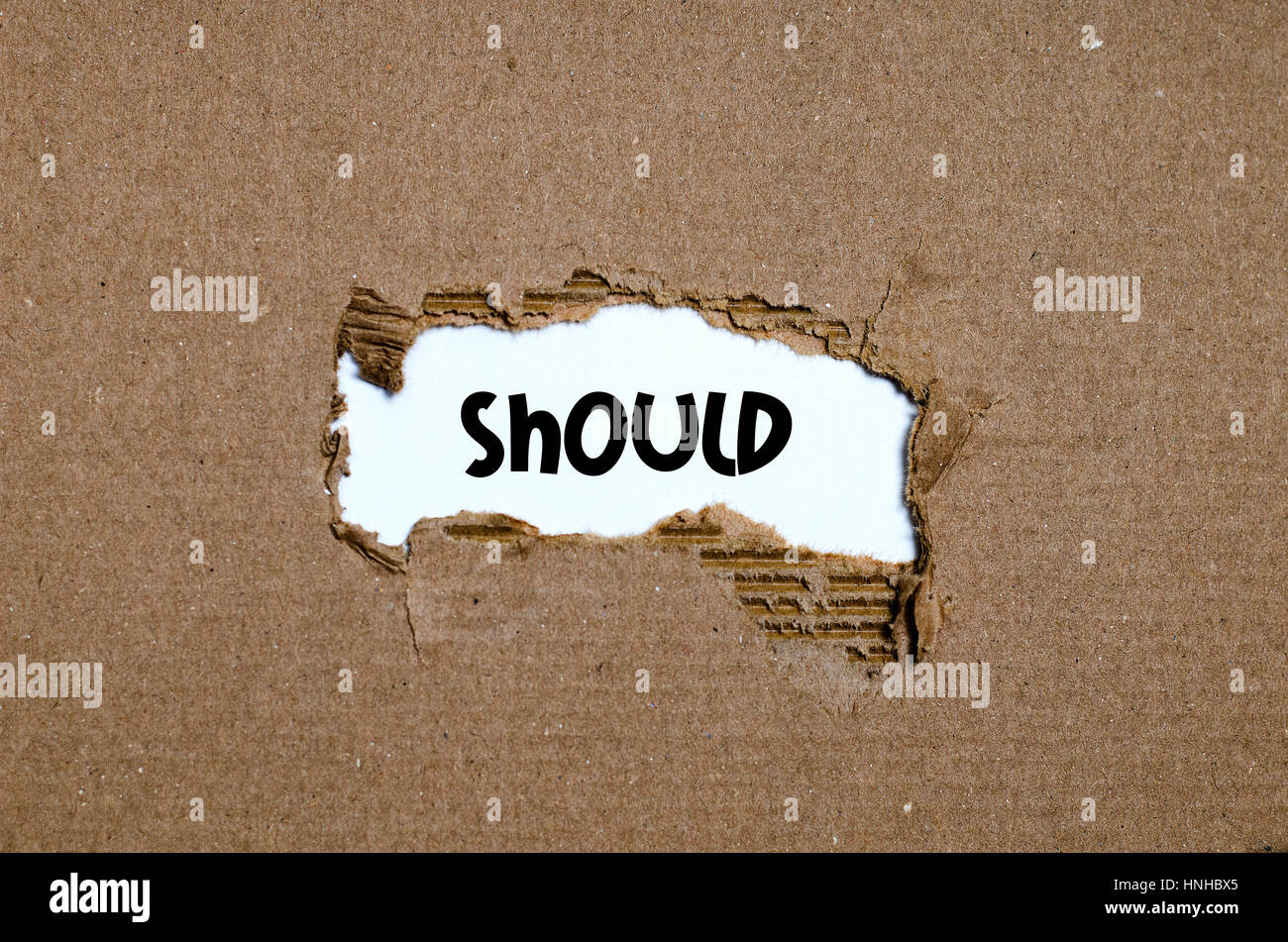 The word should appearing behind torn paper Stock Photo - Alamy
