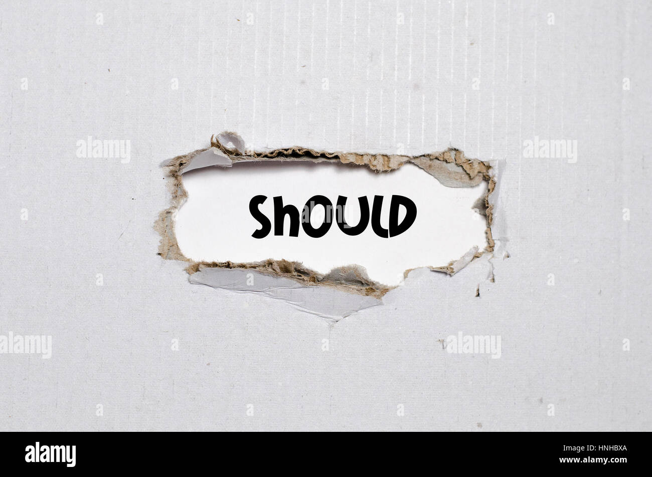 The word should appearing behind torn paper Stock Photo - Alamy
