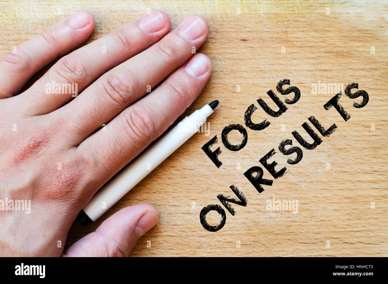Human hand over wooden background and focus on results text concept ...