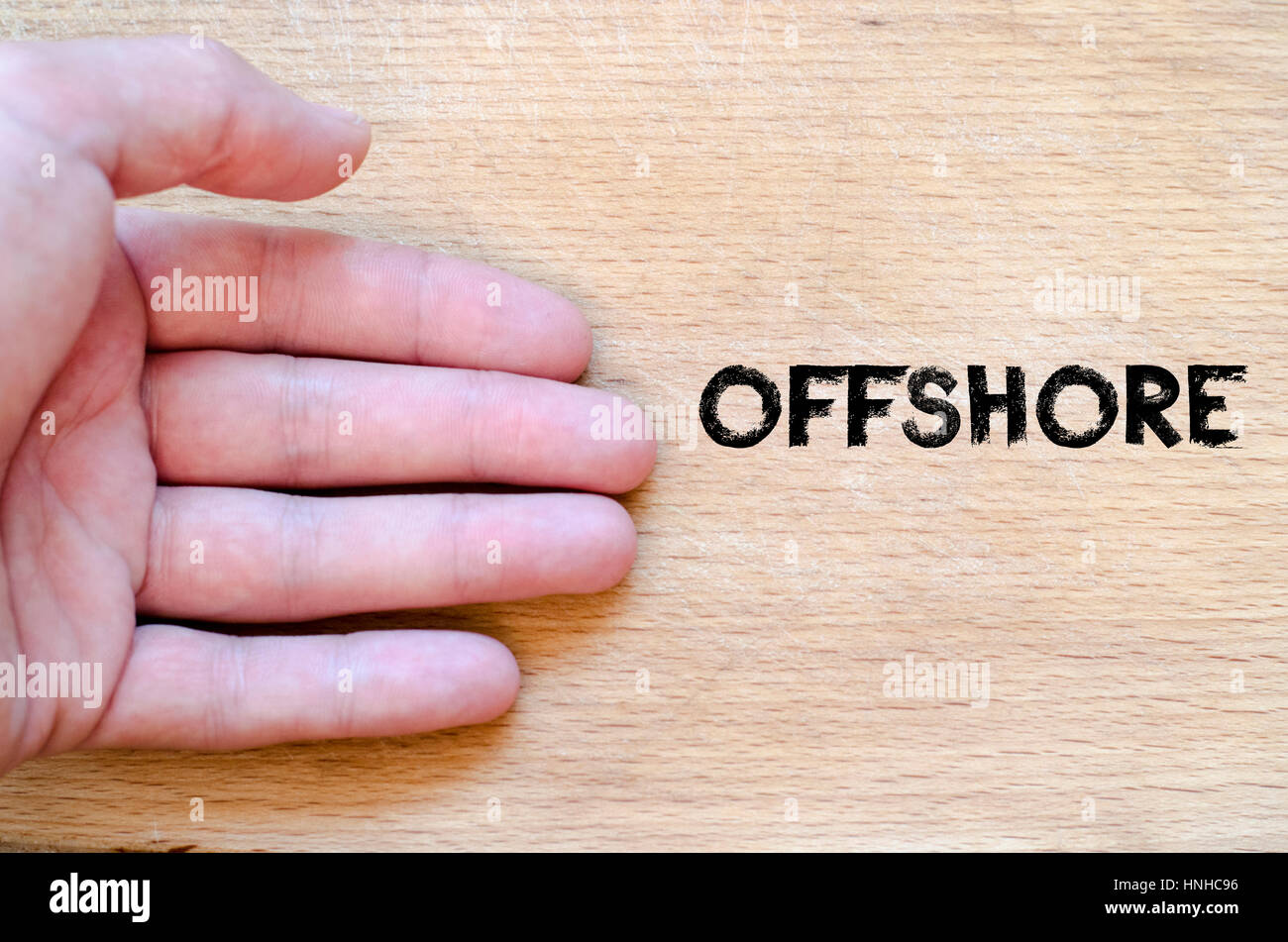 Human hand over wooden background and offshore text concept Stock Photo ...