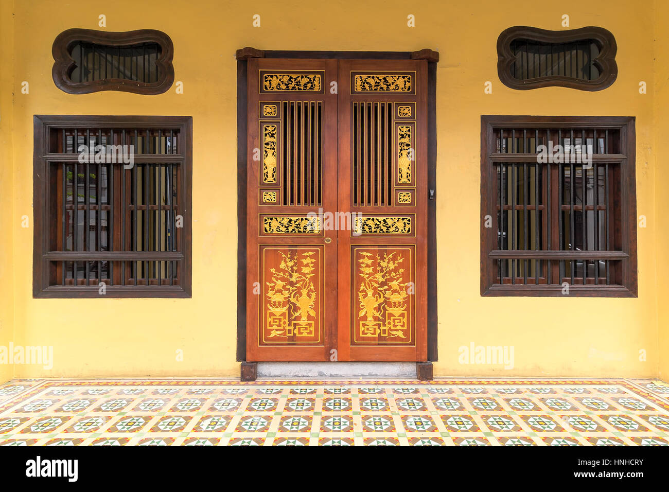 Peranakan typical style windows and ornate entrance doors an floor ...