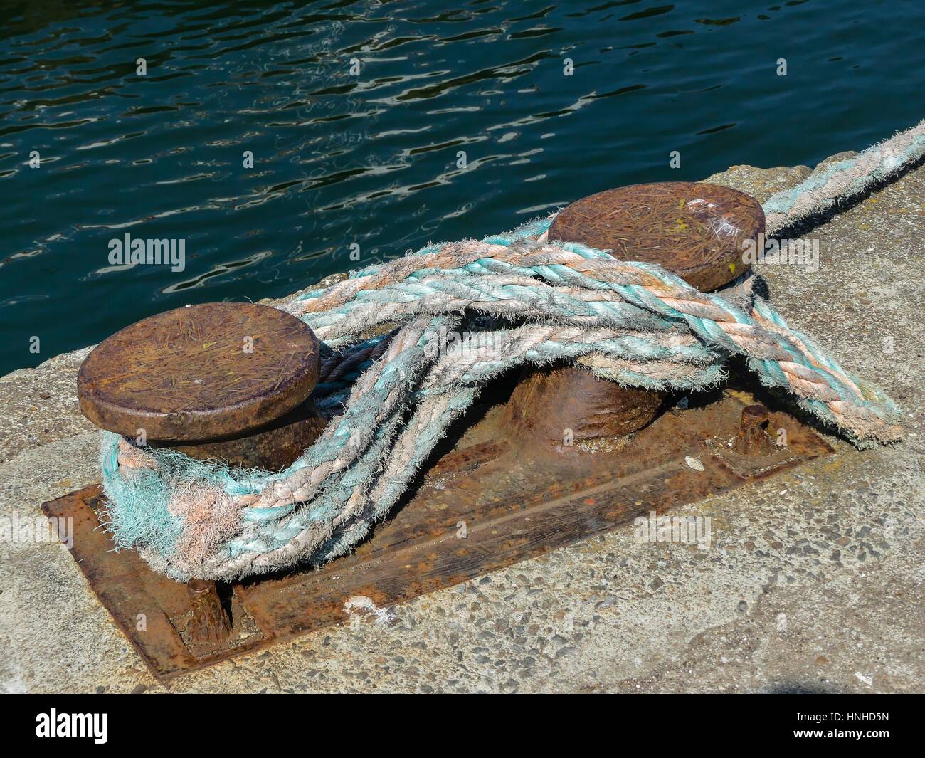 Rusty bollard with secured mooring rope at the dock Stock Photo - Alamy