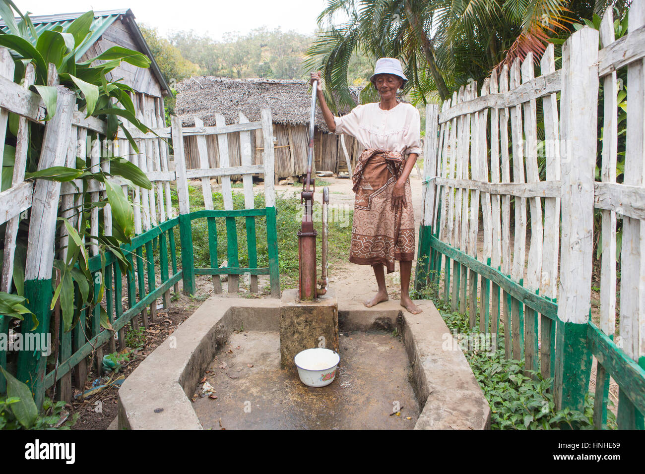 Old malagasy woman fetching drinking water in the village in Madagascar ...