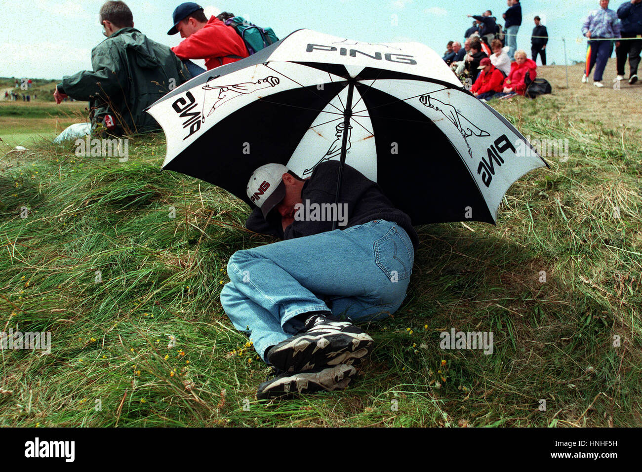 SPECTATOR TAKES COVER BRITISH OPEN ROYAL BIRKDALE 19 July 1998 Stock ...