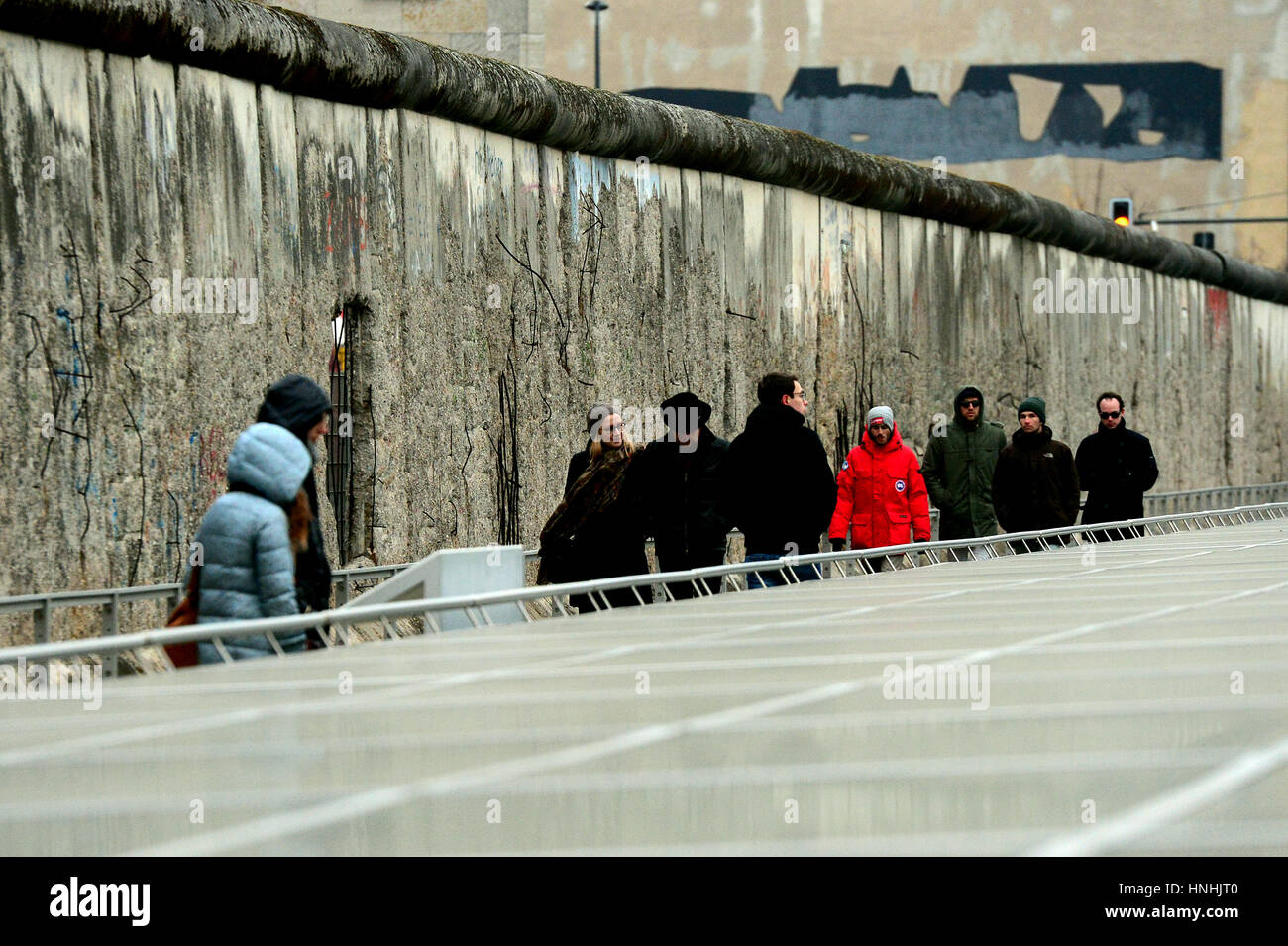 Pedestrian walk by the remnants of the Berlin wall at the memorial site ...