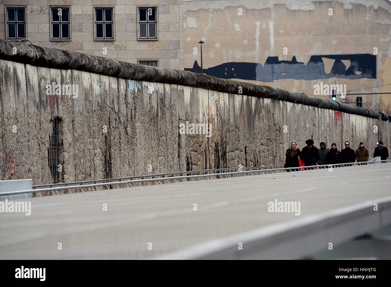 Pedestrian walk by the remnants of the Berlin wall at the memorial site ...