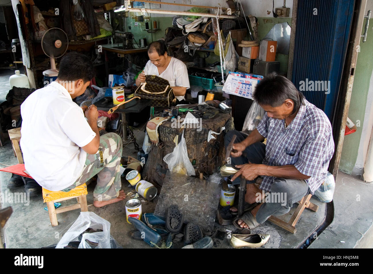 Shoemakers, shoe cobblers, leather workers repairing shoes and bag, traditional handicraft ...