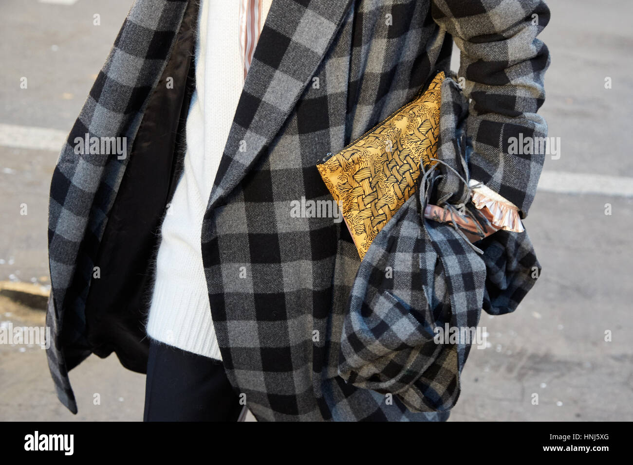 MILAN - JANUARY 14: Woman with gray checkered jacket and yellow bag ...