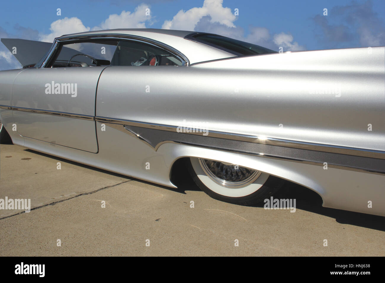 Custom silver colored vintage car, side view under blue sky Stock Photo ...