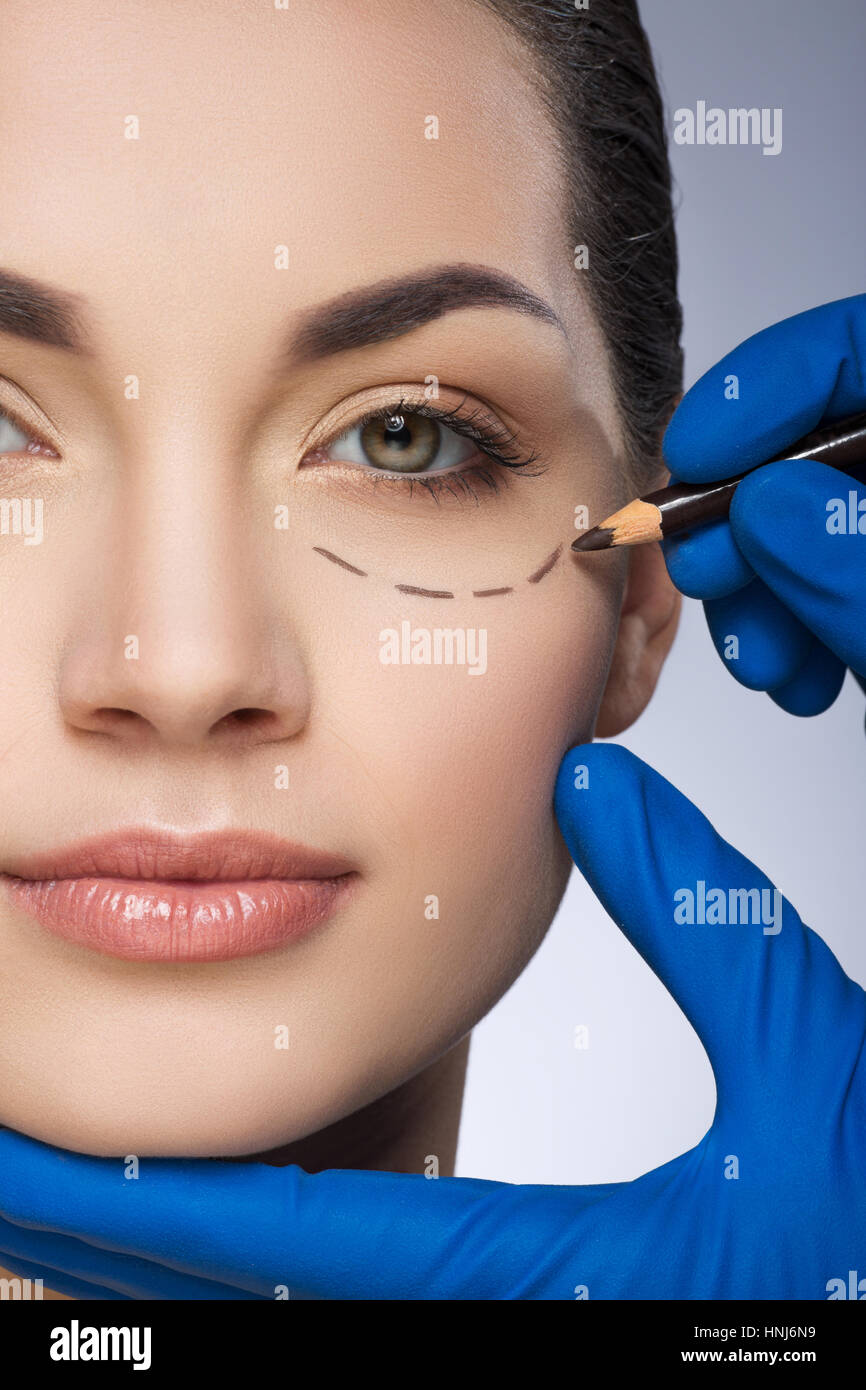 Surgeon drawing line under eye Stock Photo - Alamy