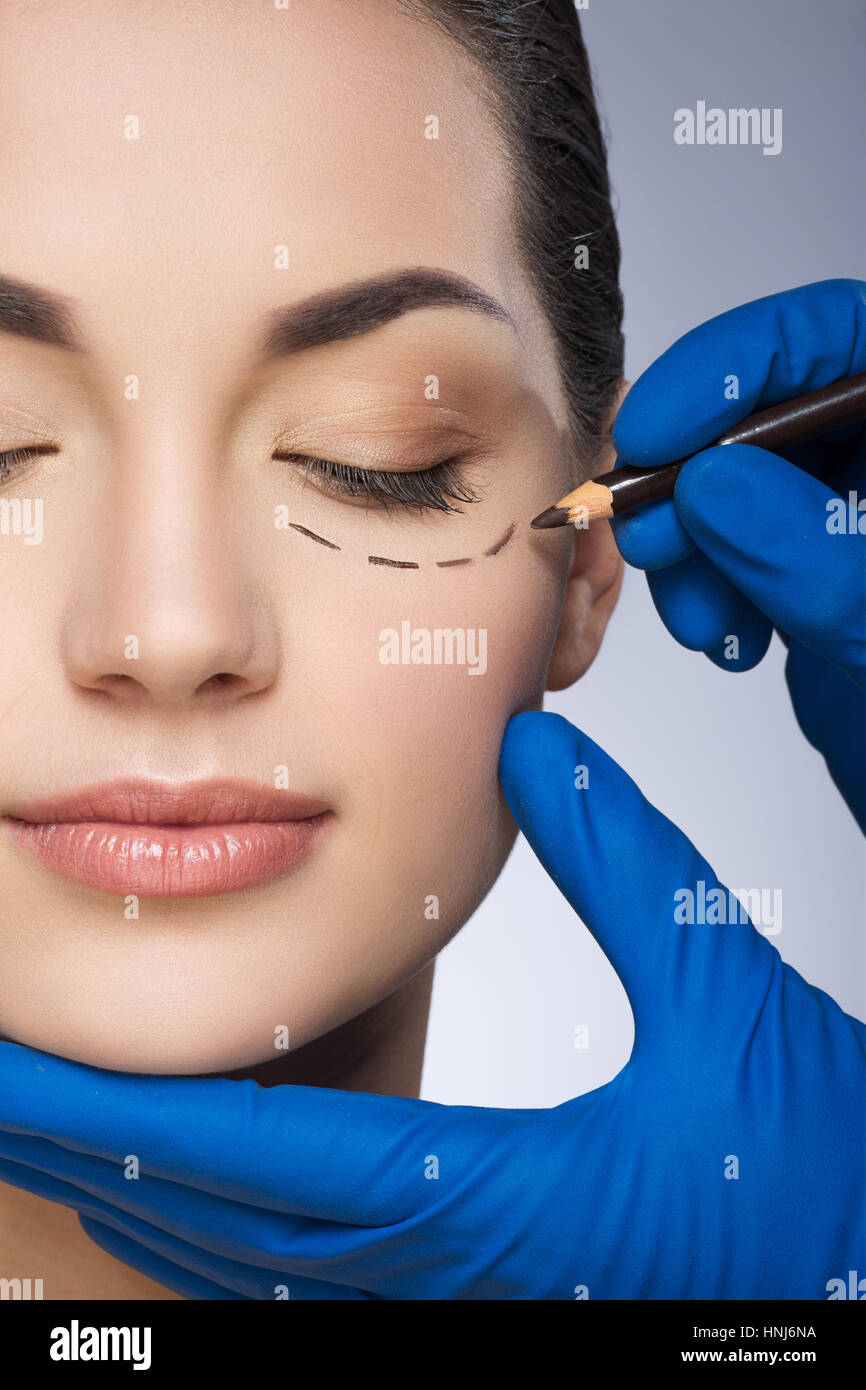 Doctor drawing line under eye Stock Photo - Alamy