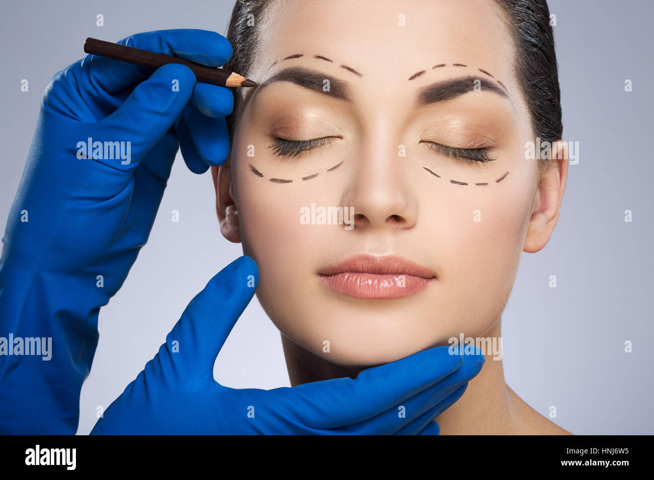 Plastic surgeon drawing dashed lines above eyebrow Stock Photo - Alamy