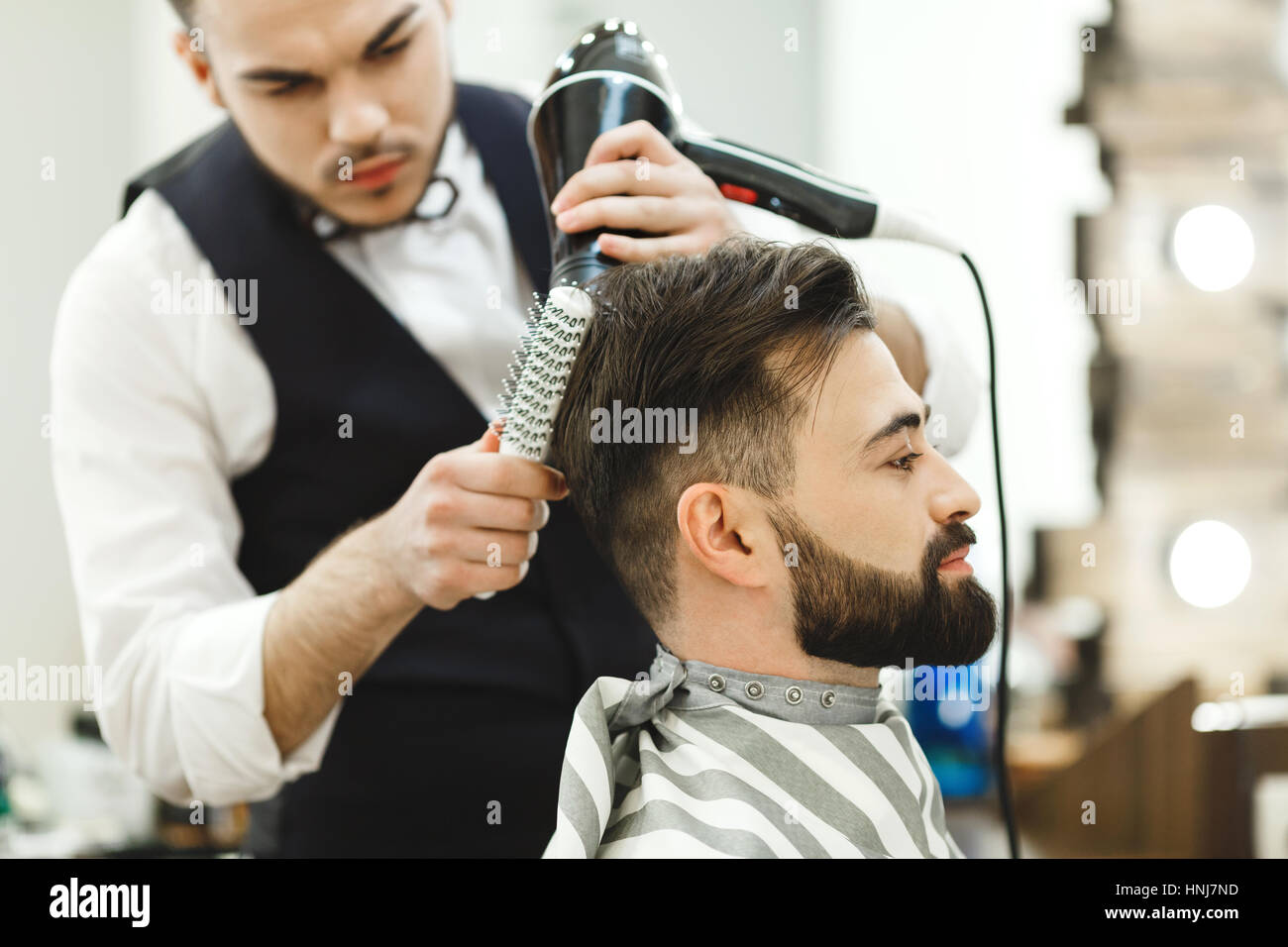 Dark haired barber doing a haircut Stock Photo - Alamy