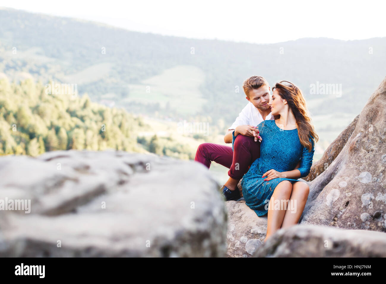 Cute couple on top of rock Stock Photo - Alamy