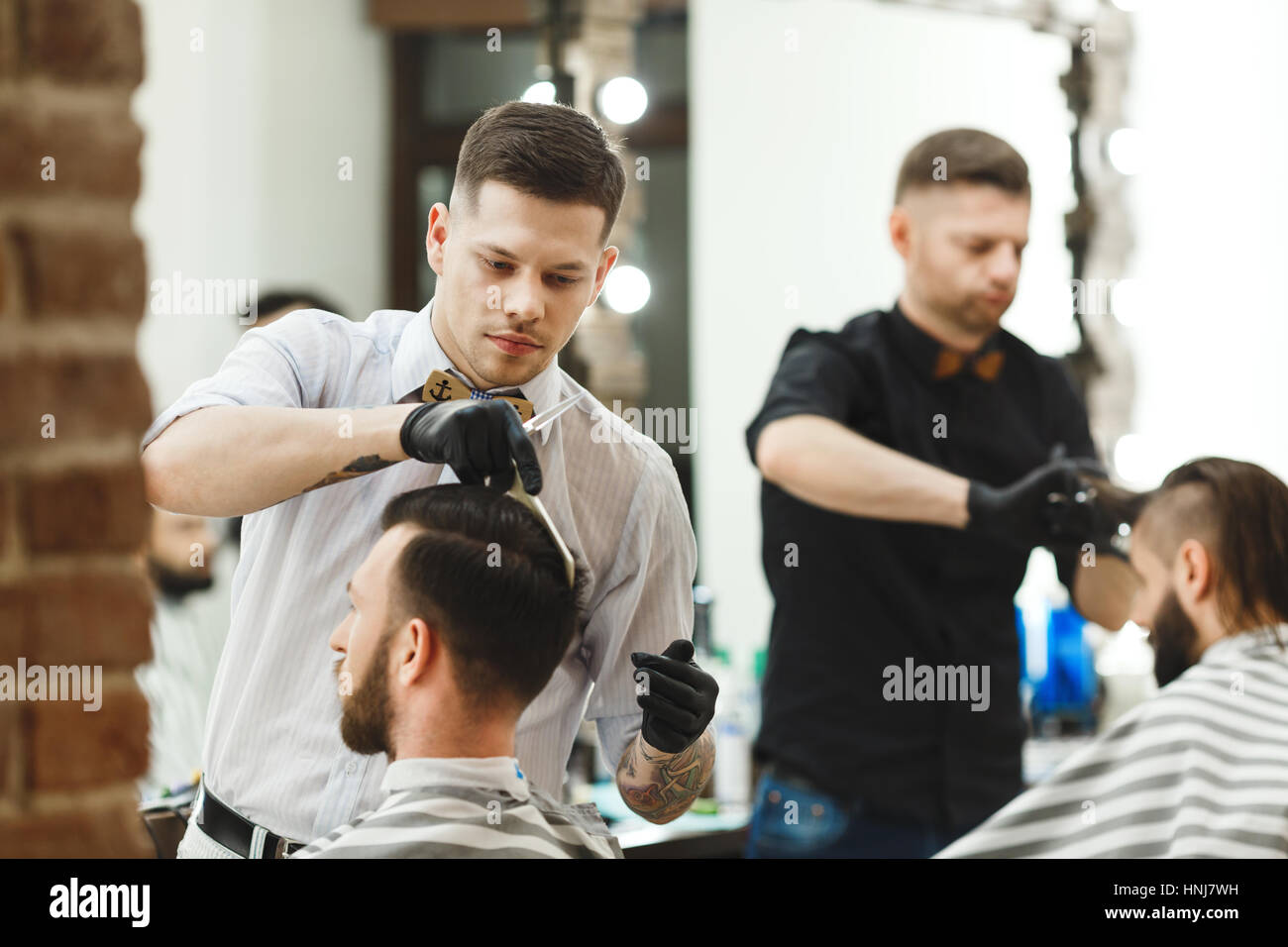 Barbers doing haircuts for clients Stock Photo - Alamy