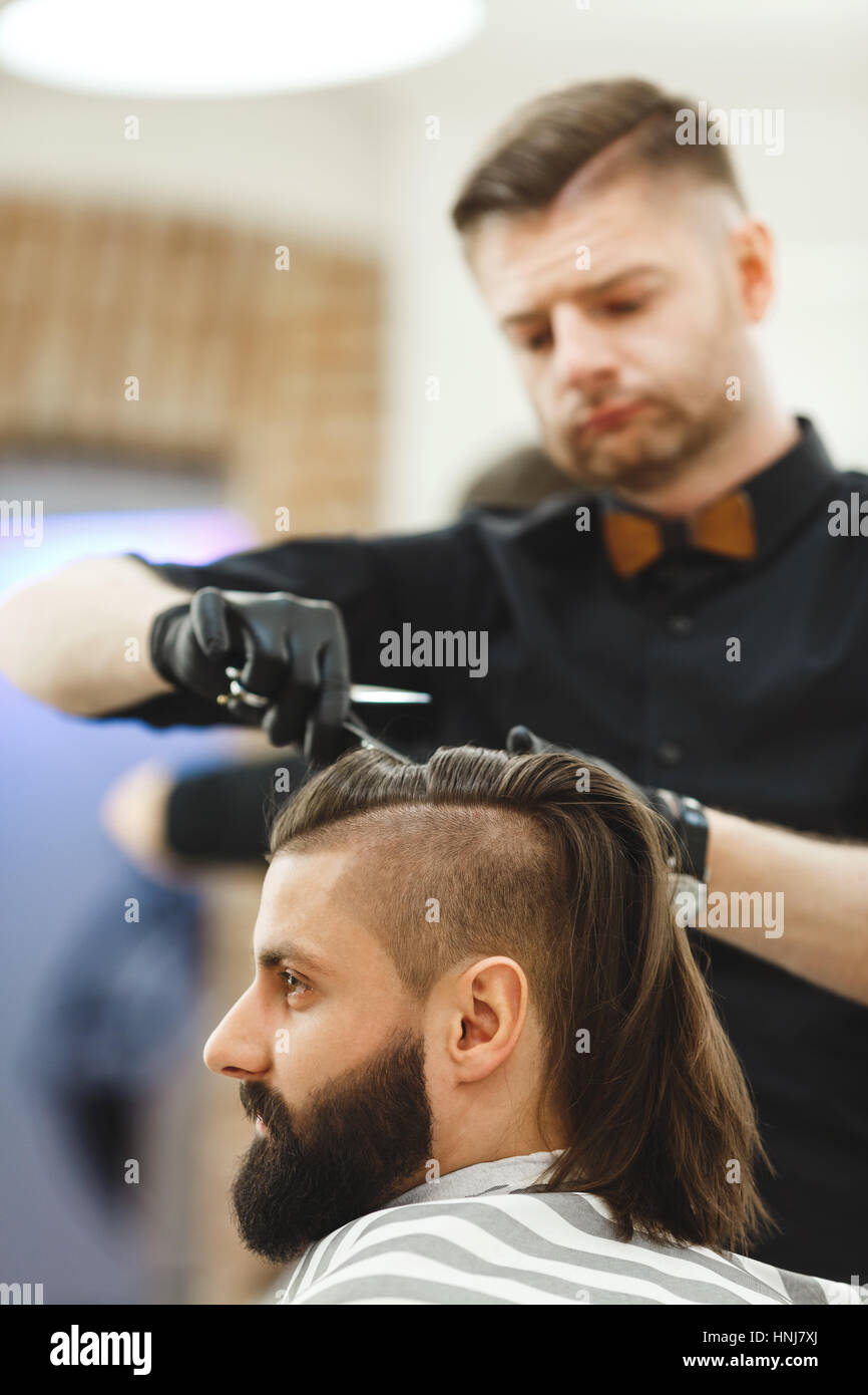 Barber doing haircuts for client Stock Photo - Alamy