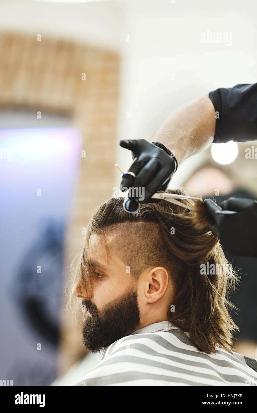 Barber doing haircuts for client Stock Photo - Alamy