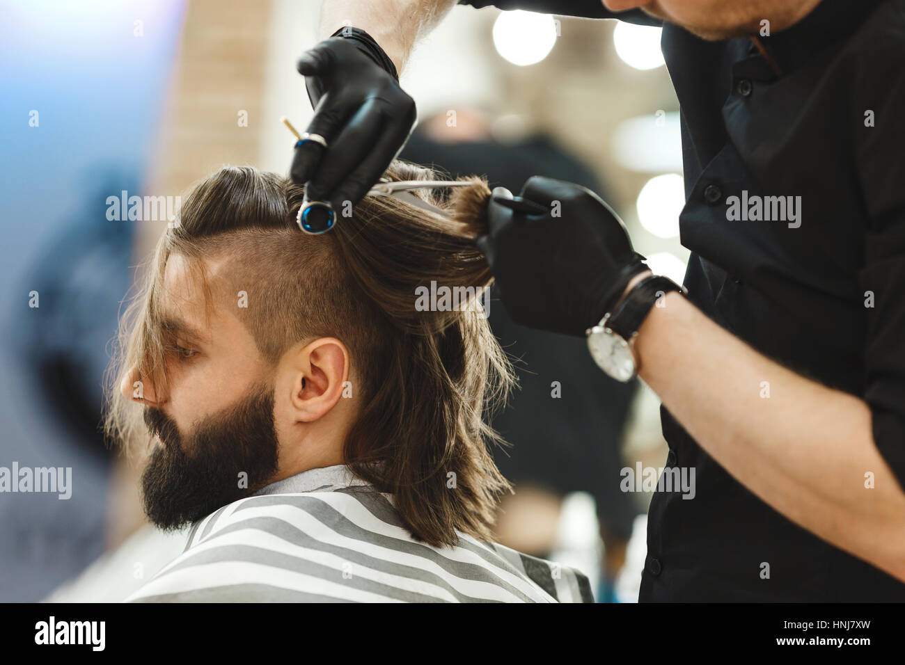 Barber doing haircuts for client Stock Photo - Alamy