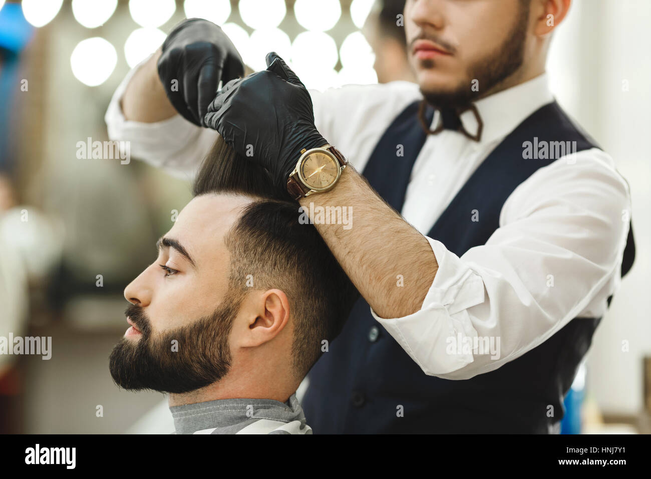 Barber doing haircuts for client Stock Photo - Alamy