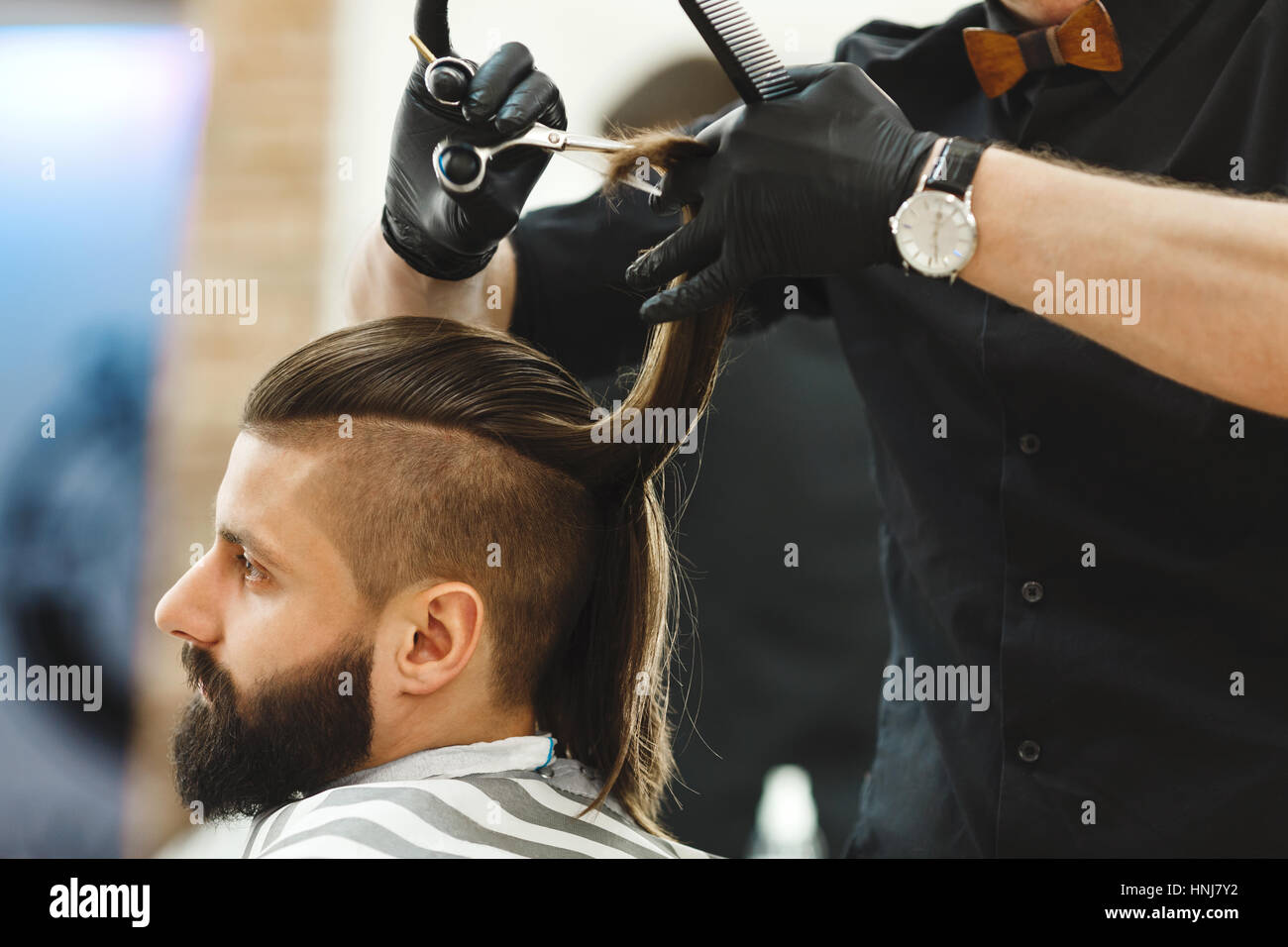 Barber doing haircuts for client Stock Photo - Alamy