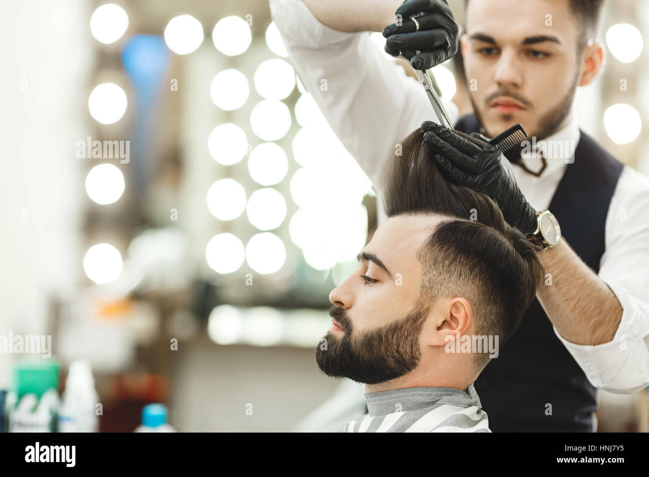 Barber doing haircuts for client Stock Photo - Alamy